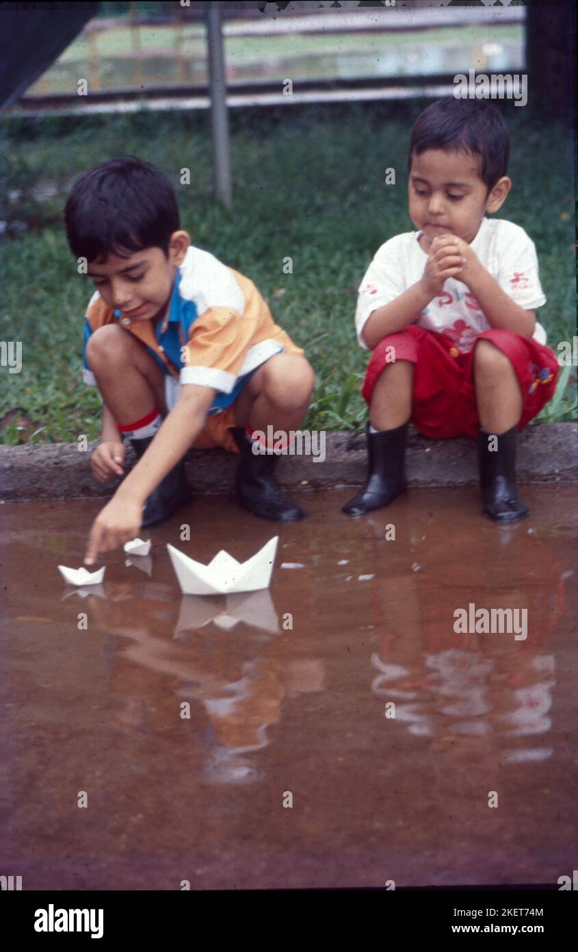Children Playing with Paper Boats in Rain Puddle, Mumbai, India Stock ...