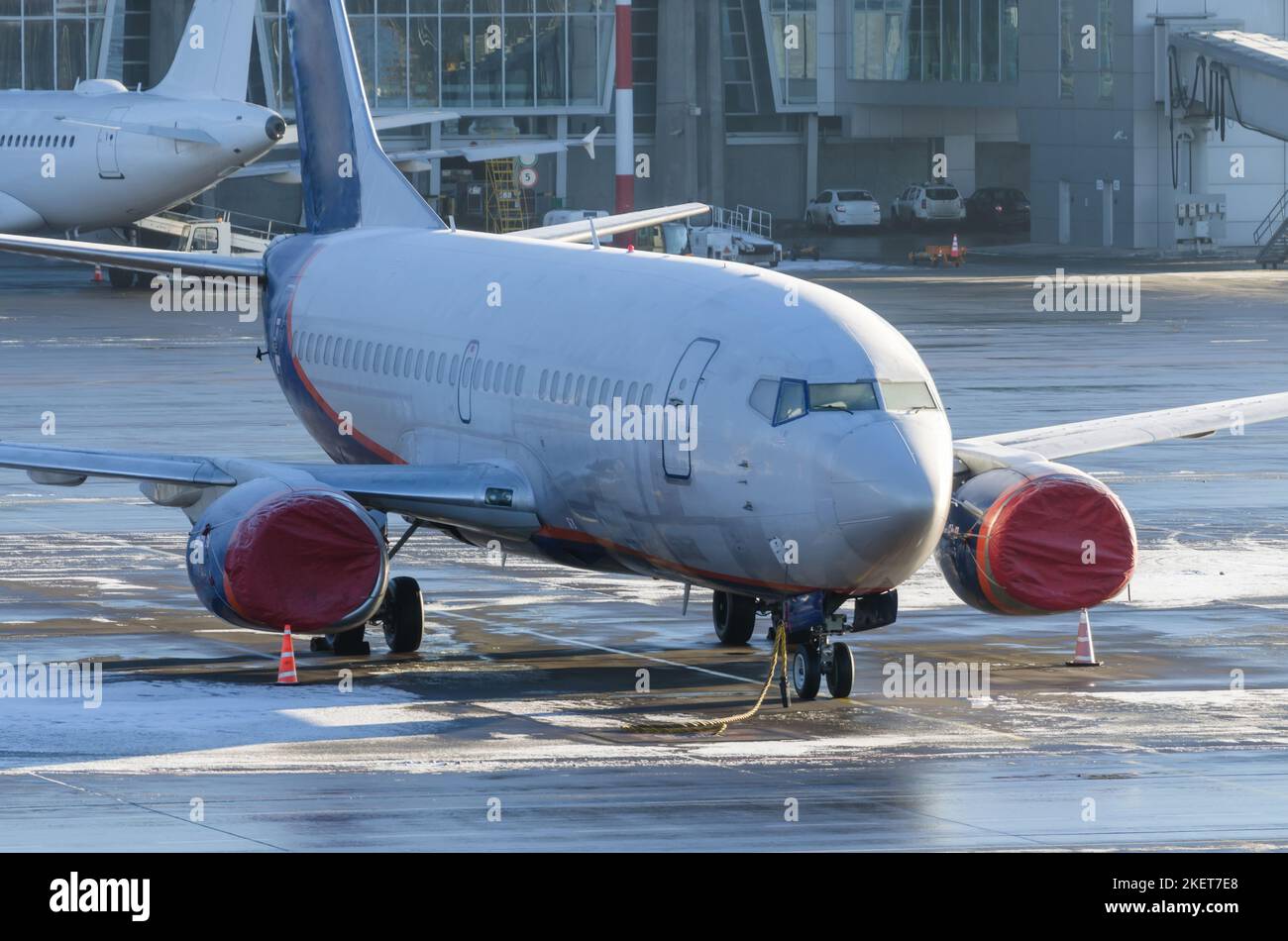 Airplane in the parking lot with engines covered, frozen in ice in ...