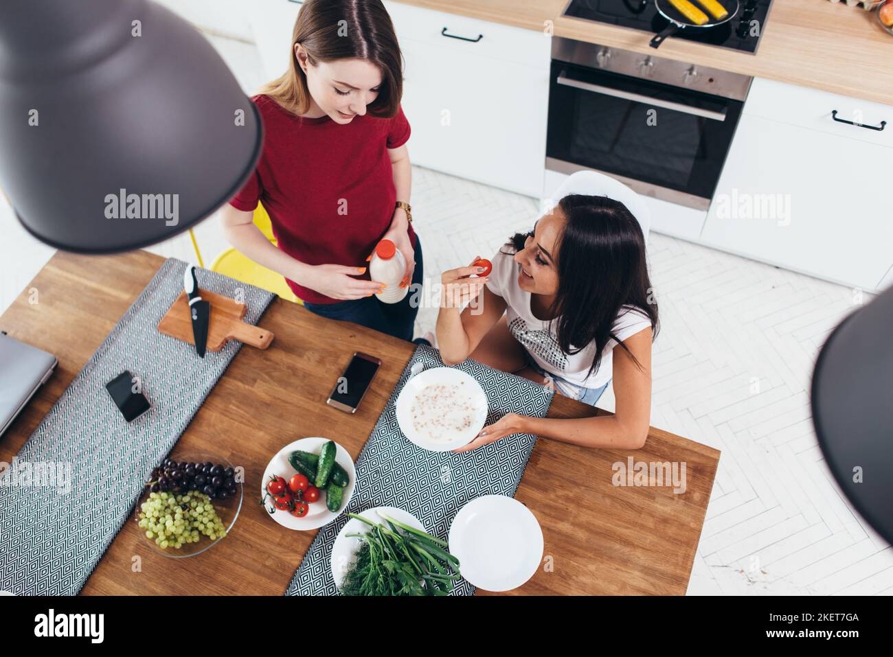 Two young women having breakfast at home. Top view Stock Photo - Alamy