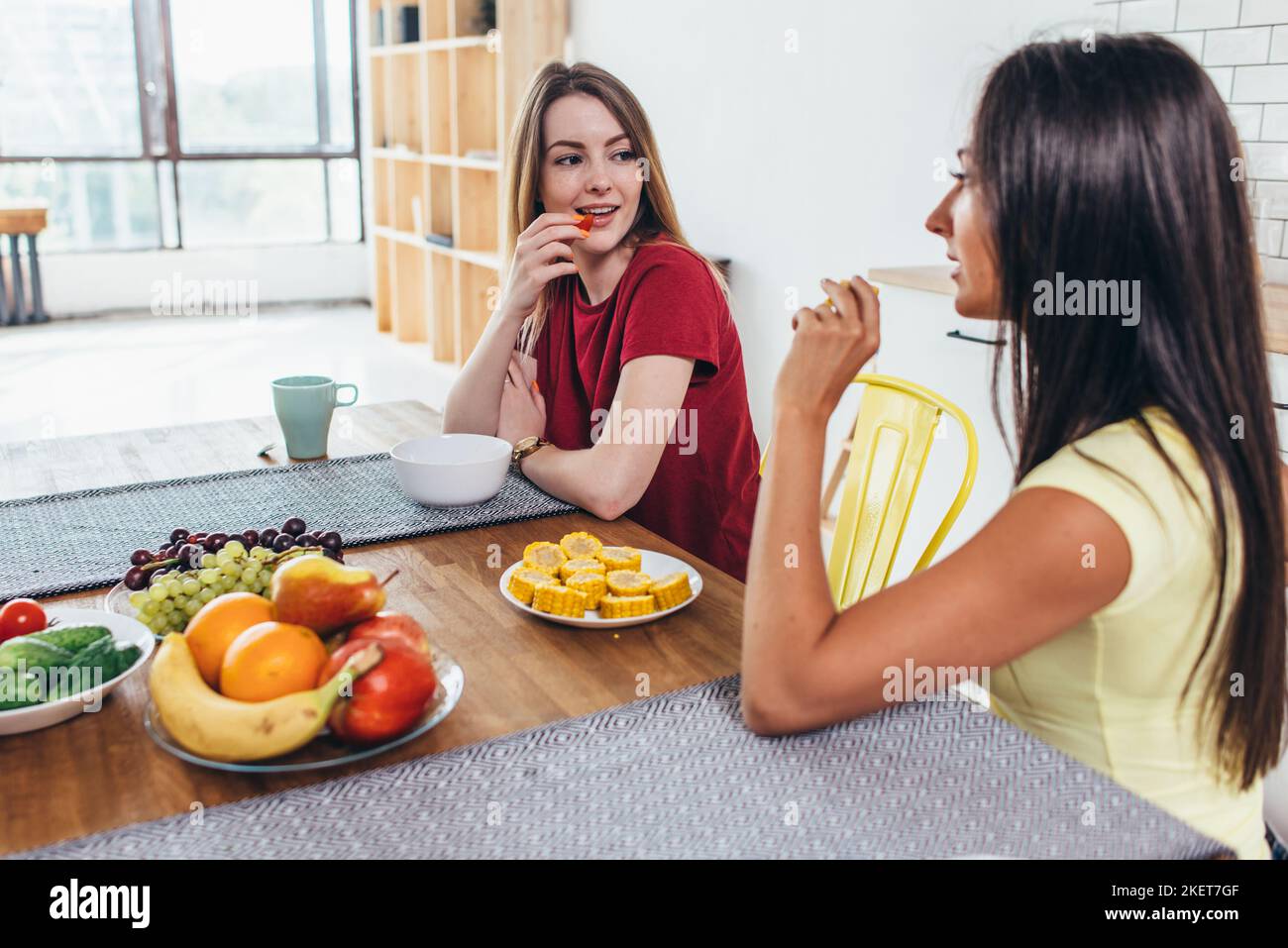 Women friends having fruits at breakfast in kitchen Stock Photo - Alamy