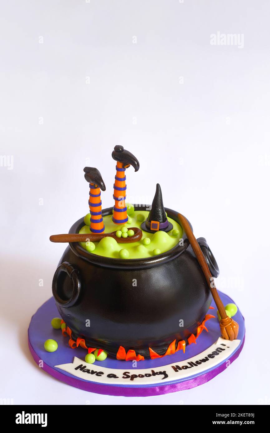 Fun and scary Halloween cake on white background. Witch hat, legs, and ...