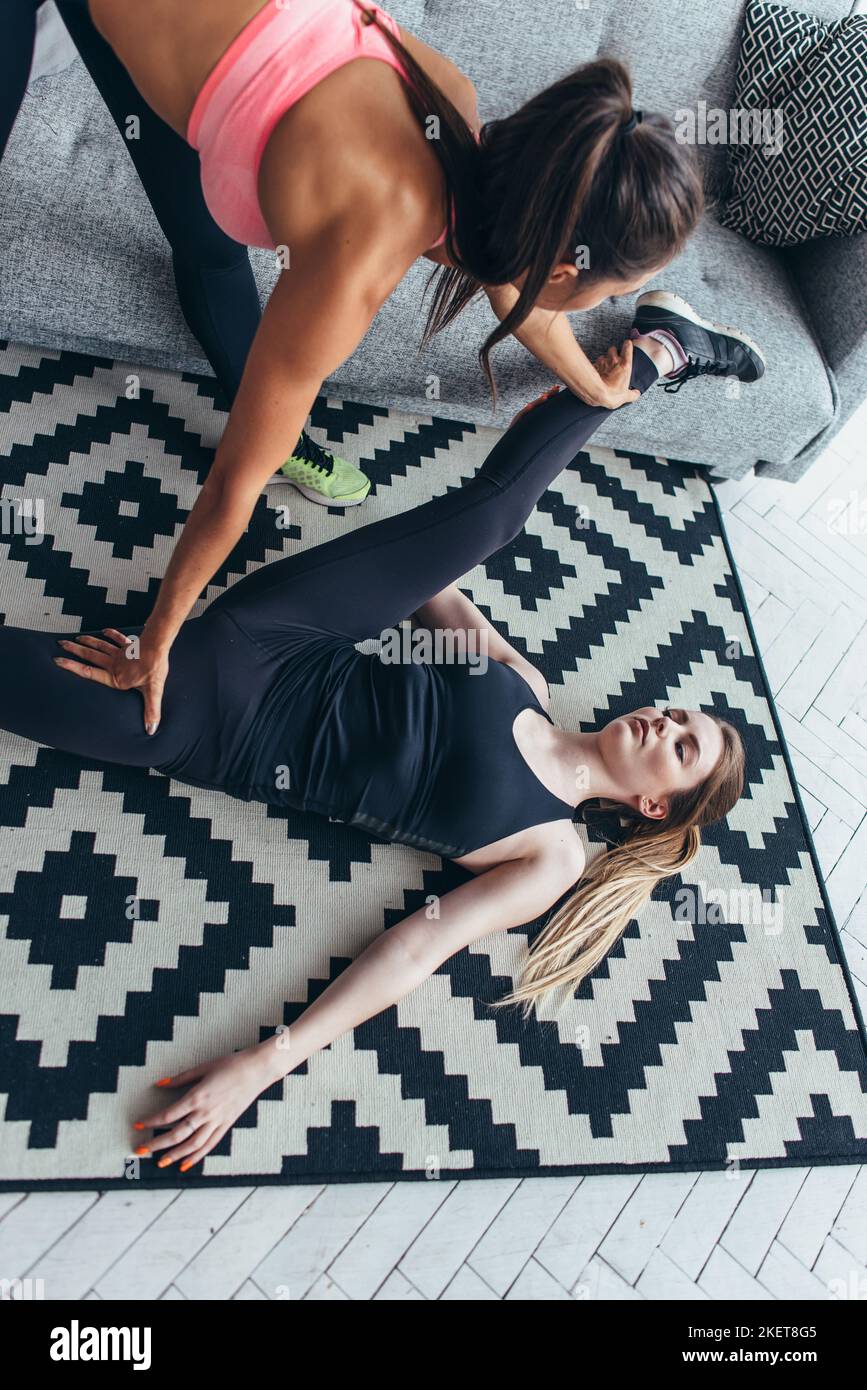 Fit Young Woman Doing Stretching Exercises With The Help Of Personal