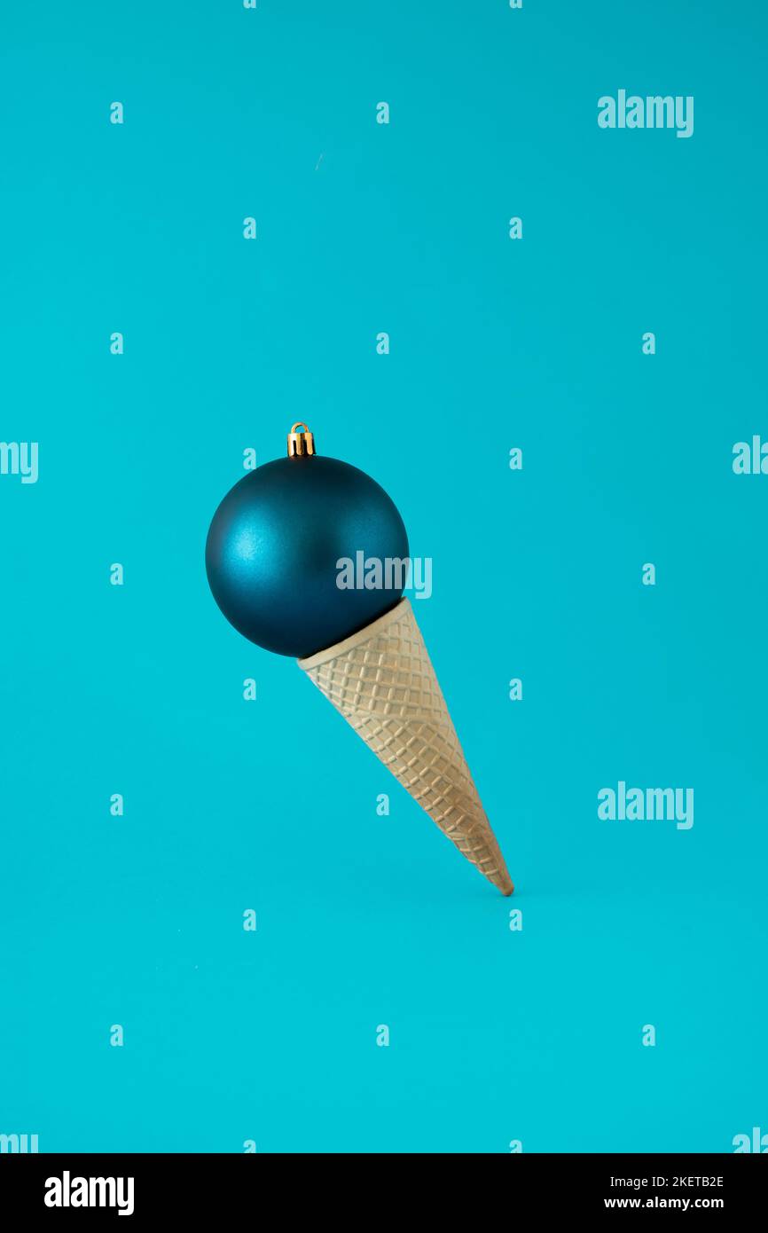Ice cream with Christmas bauble on waffle on blue background. Holiday ...