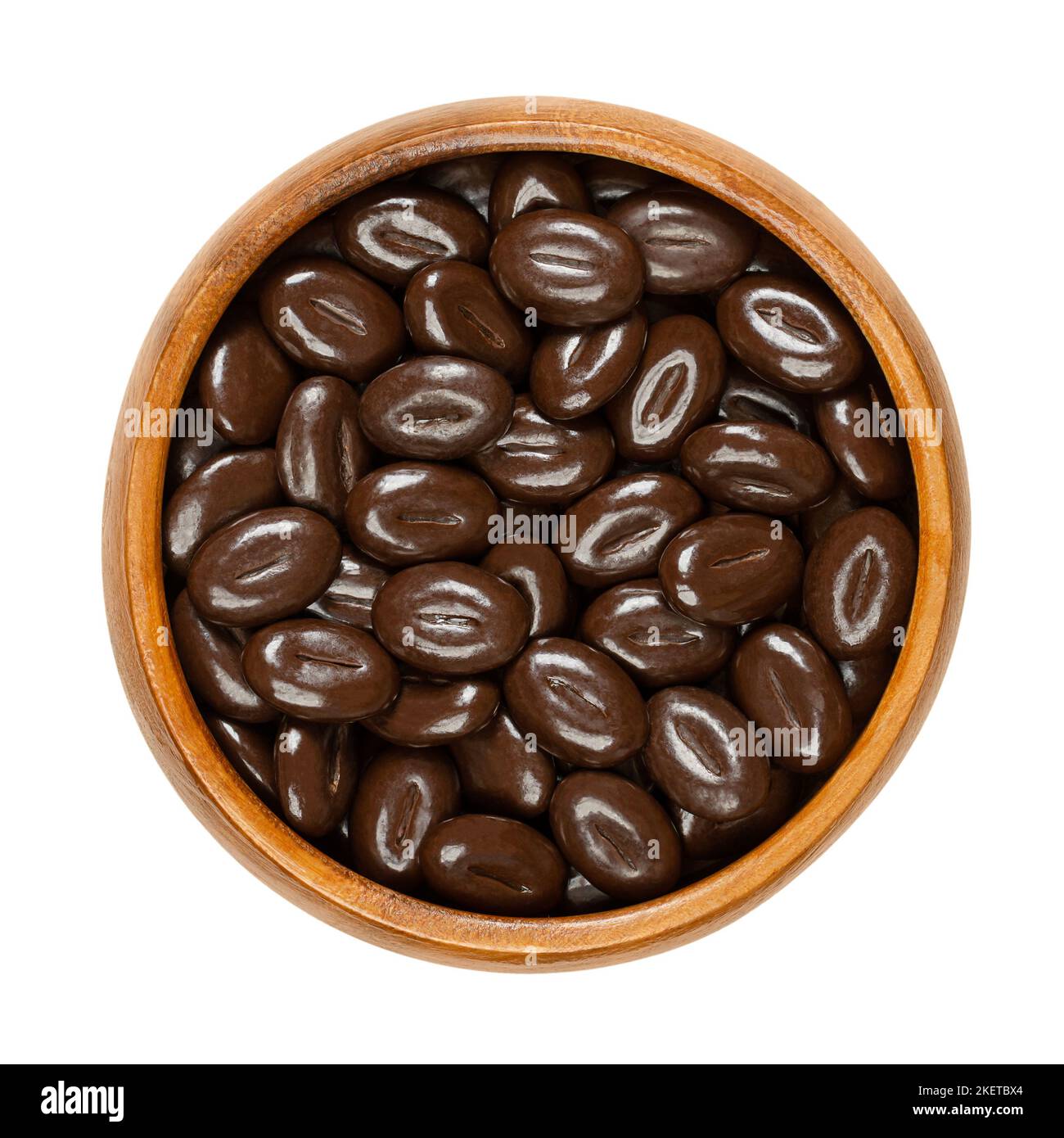 Dark chocolate mocha beans, in a wooden bowl. Candies made of a mixture ...