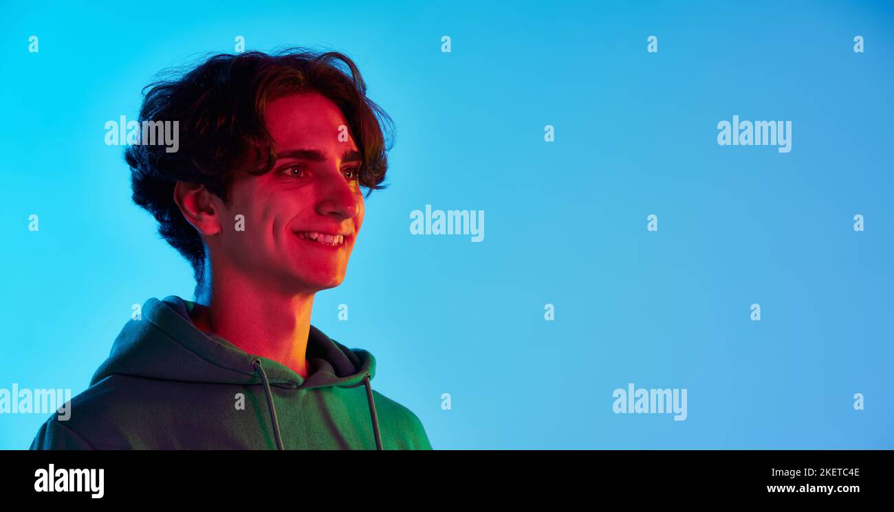 Portrait of young man with curly hair posing, smiling isolated over ...