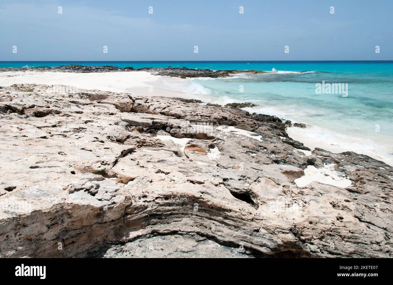 The scenic view of eroded rocks and a sandy beach on Half Moon Cay ...