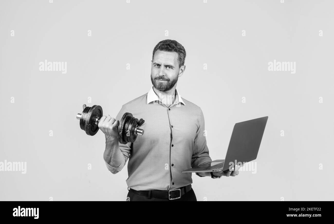 Multitasking skills. Professional man lift dumbbell using laptop ...