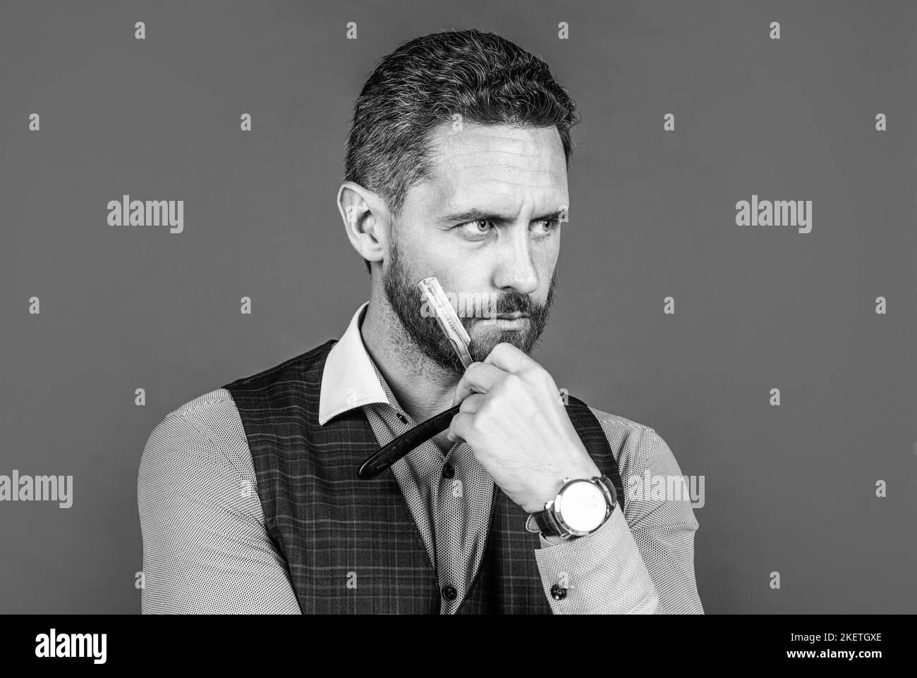 mature serious man barber with wristwatch shaving with retro razor ...