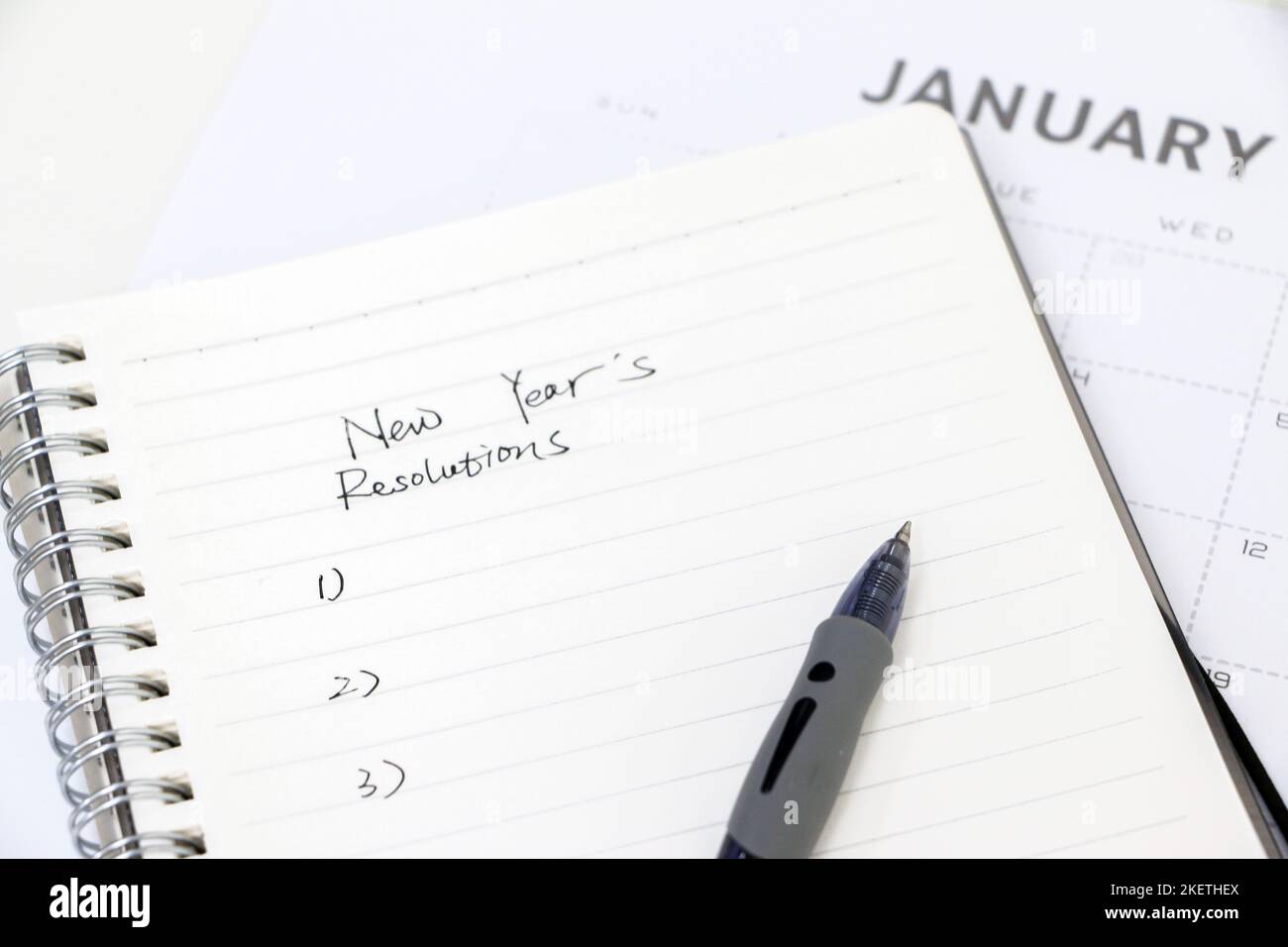 Writing new year’s resolutions, list on notepad with ballpoint pen ...