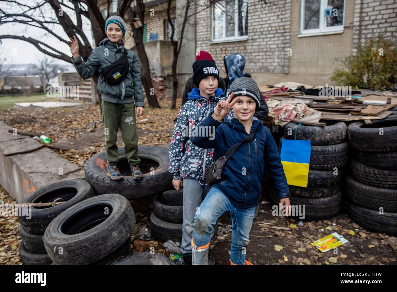 Children at the checkpoint show the sign of victory while playing ...