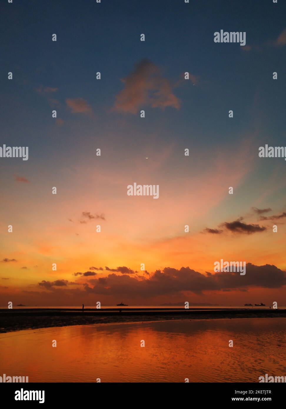 Fiery sunset with clouds by the ocean Stock Photo - Alamy