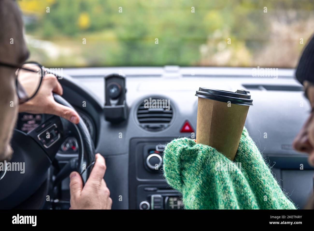 Rear back view from passenger seat of man and lady sitting inside car ...