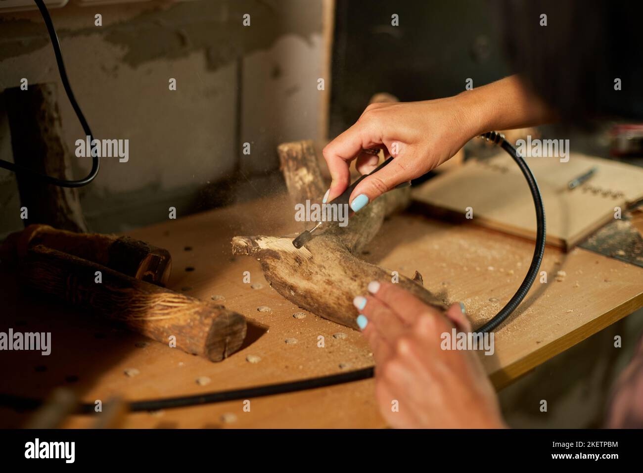 Female using power wood working tools graver, carving while crafting ...