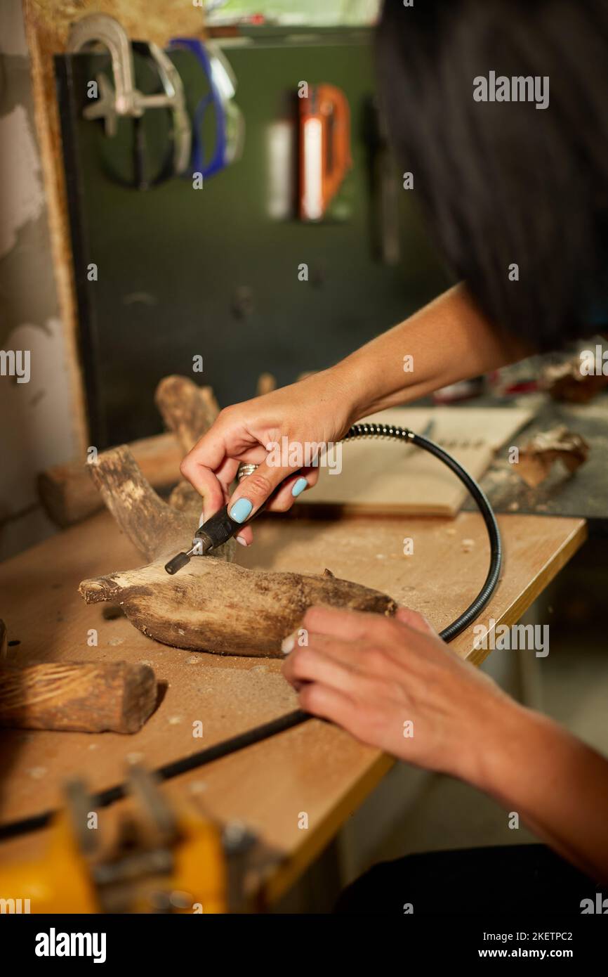 Female using power wood working tools graver, carving while crafting ...