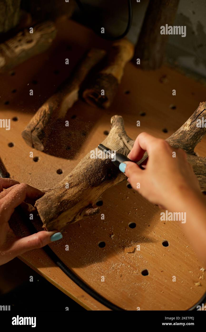 Female using power wood working tools graver, carving while crafting ...