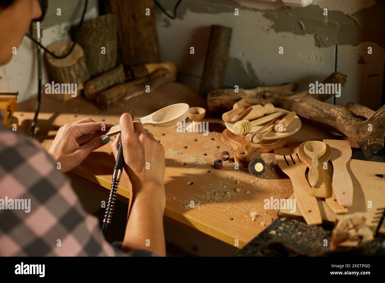 Female using power working tools graver for wooden utensils spoon ...
