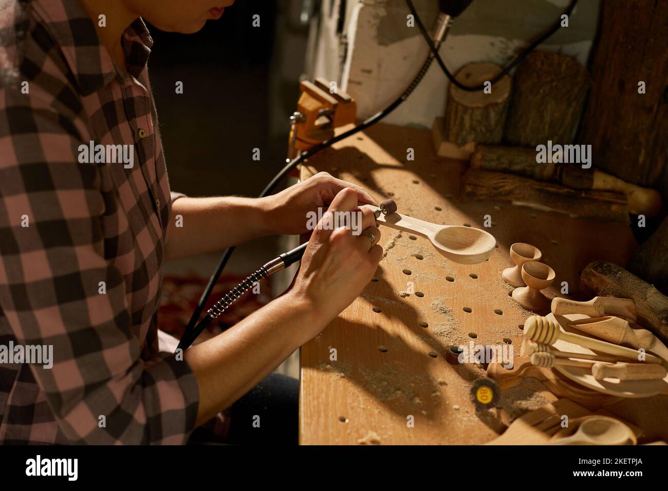 Female using power working tools graver for wooden utensils spoon ...