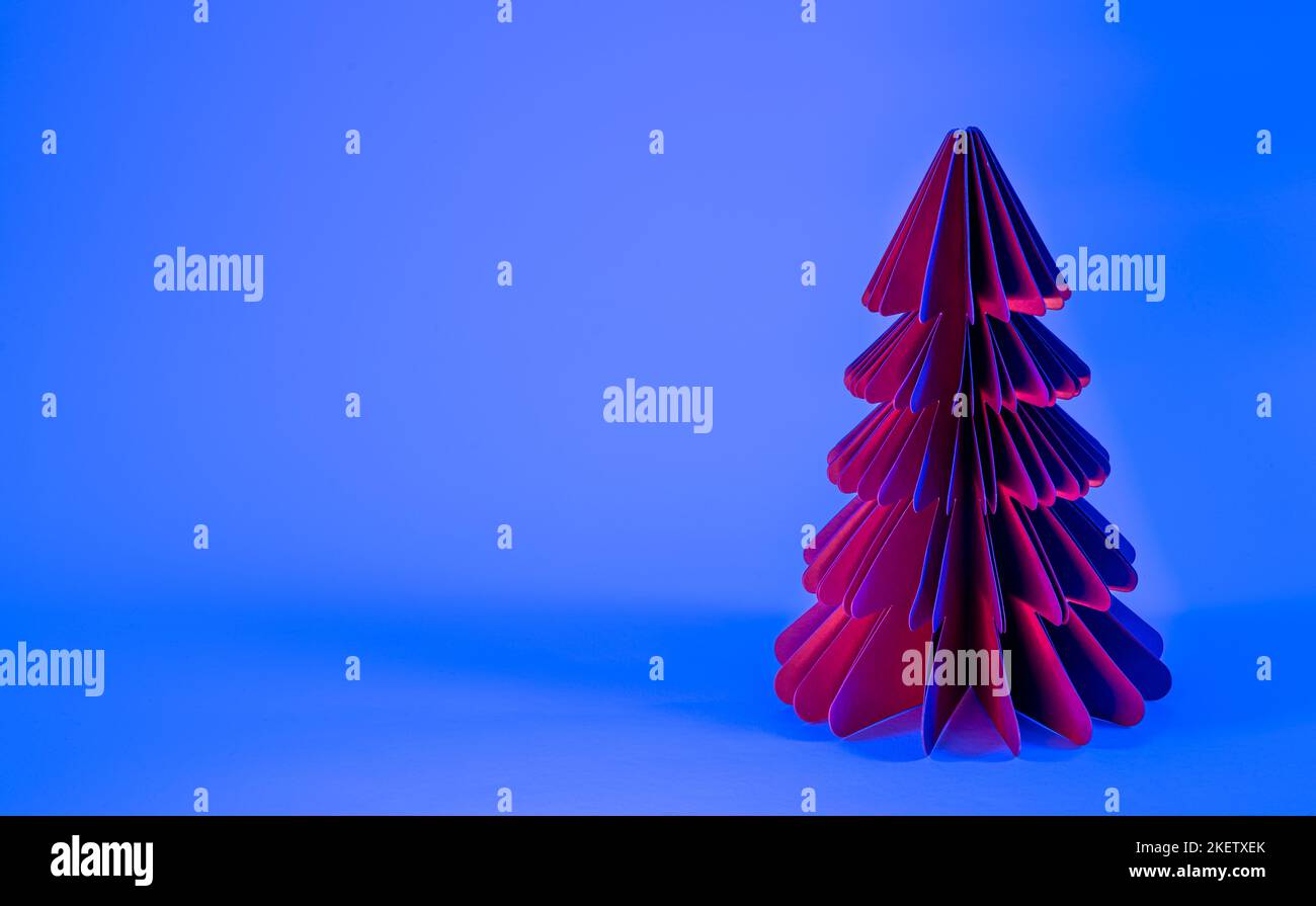 Decorative paper Christmas tree on blue background with trendy neon ...