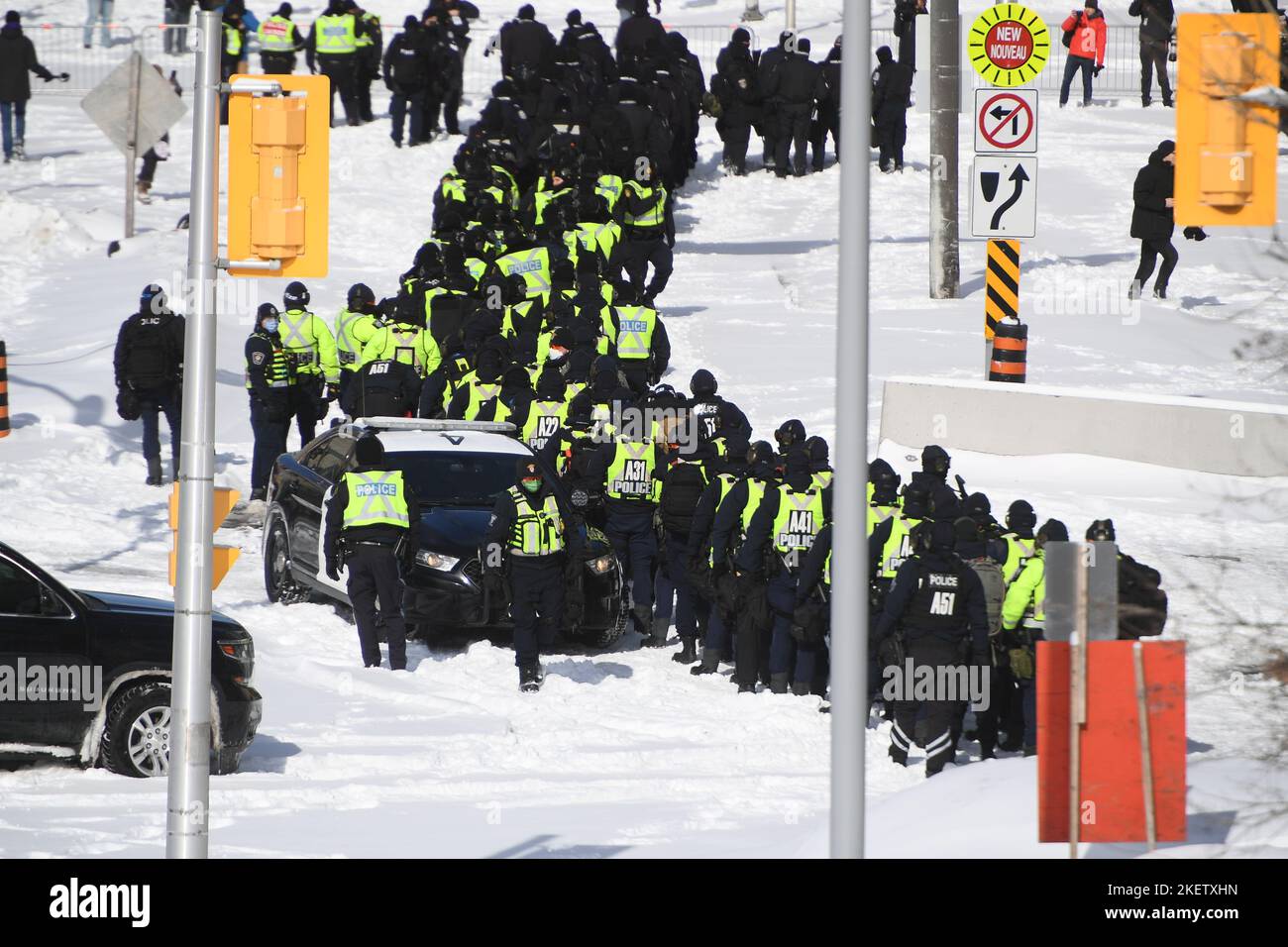 A lineup of police officers assemble on Colonel By Drive near the truck ...