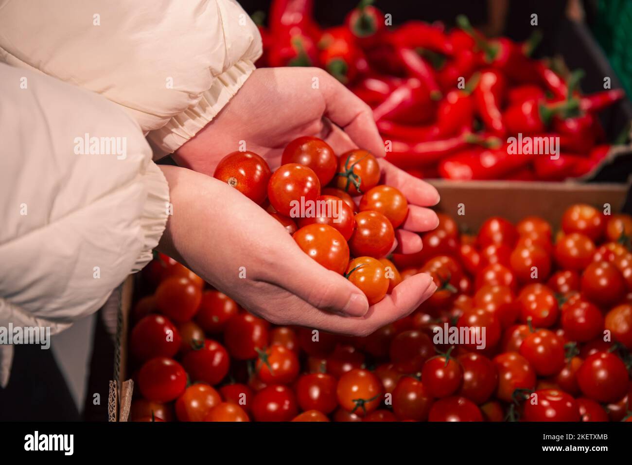A woman chooses cherry tomatoes in a grocery store, close-up Stock ...