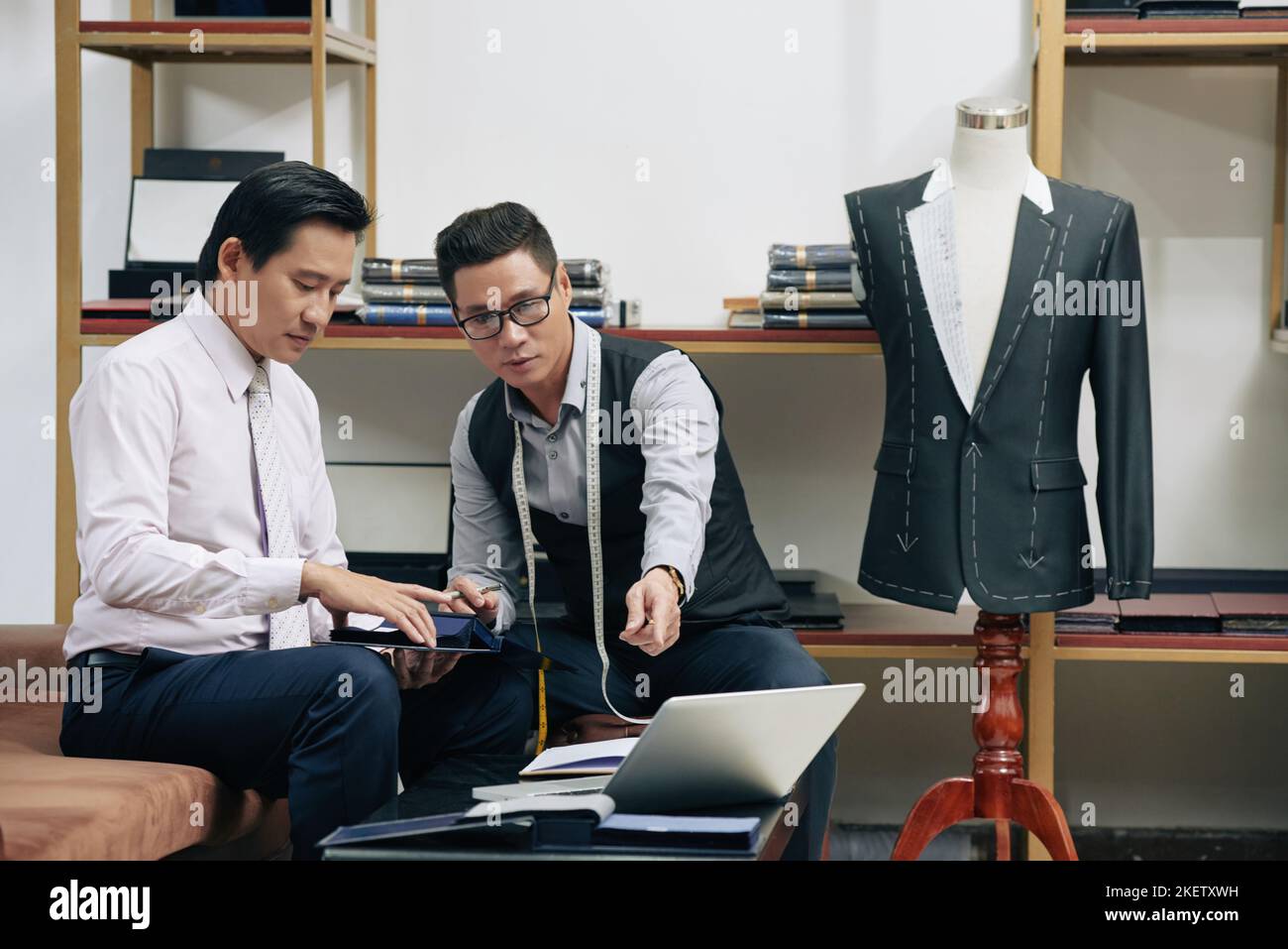 Team of professional tailor discussing ideas for new fashion collection ...