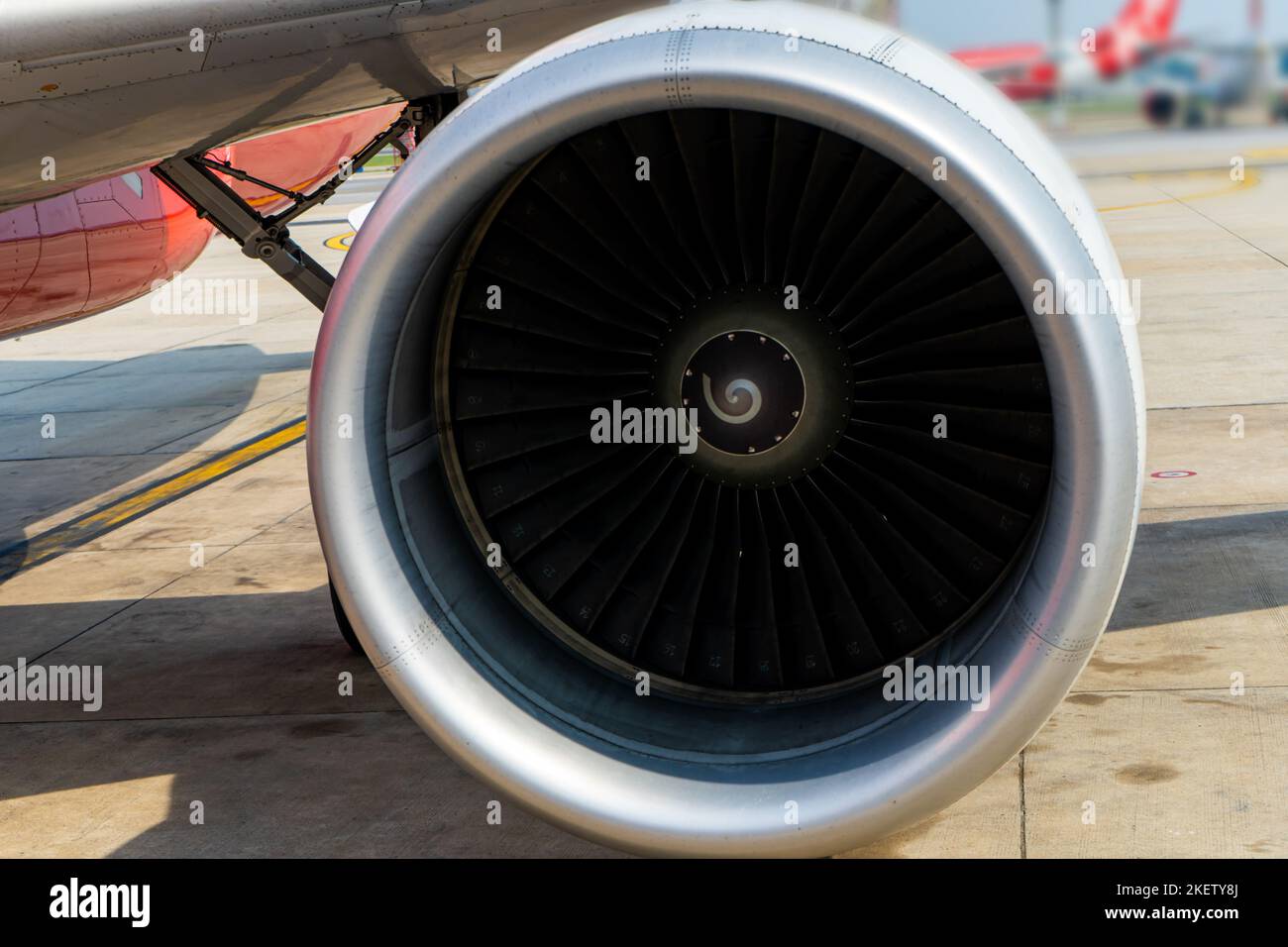 Close-up of a turbine engine of a passenger plane in an airport parking ...
