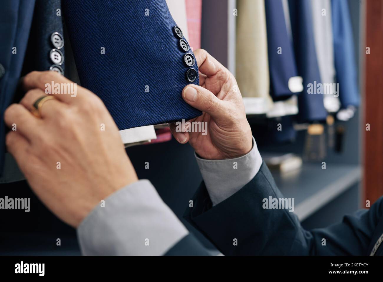 Close-up image of customer checking details of jacket before trying it ...
