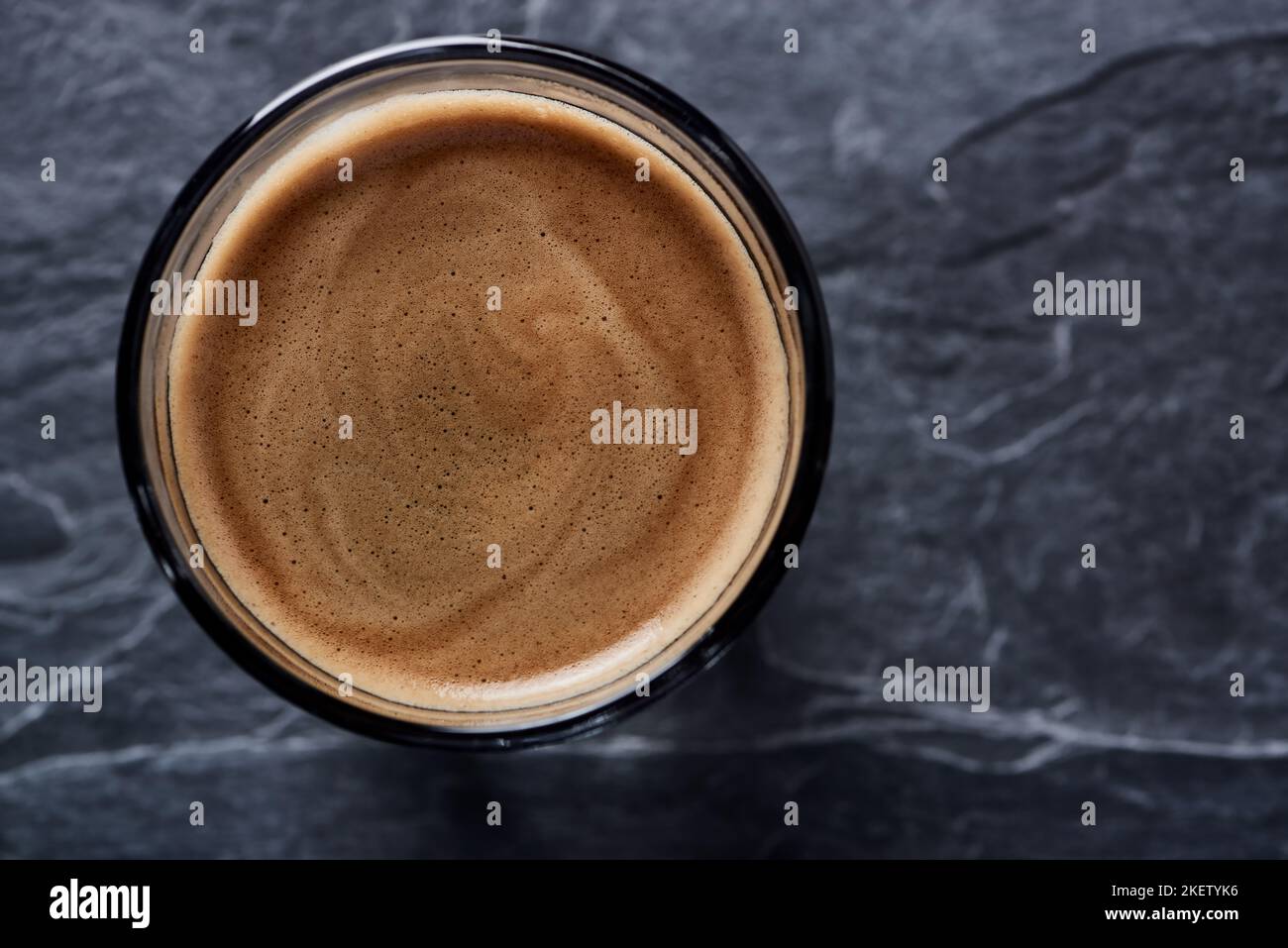Coffee in glass cup on dark stone background. Top view. Close up. Copy ...