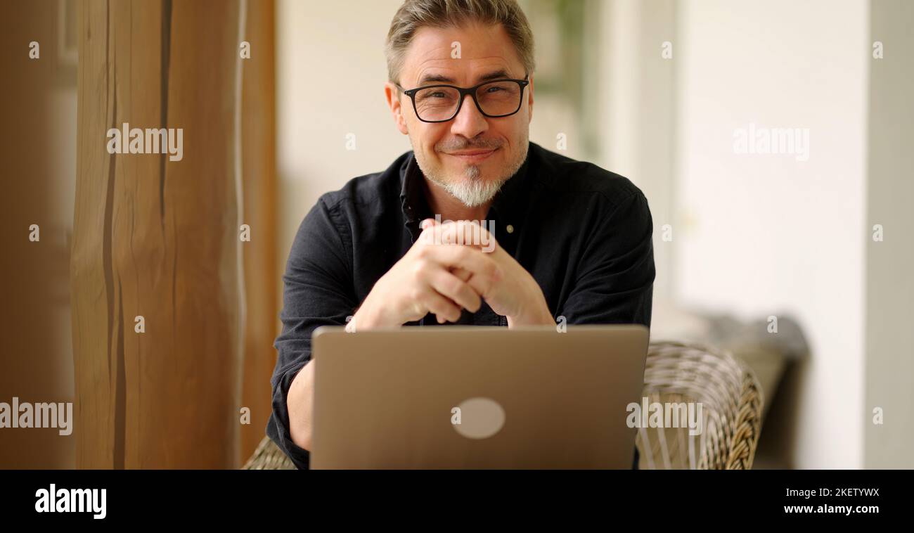 Middle aged man working with laptop computer at home outdoor i on ...