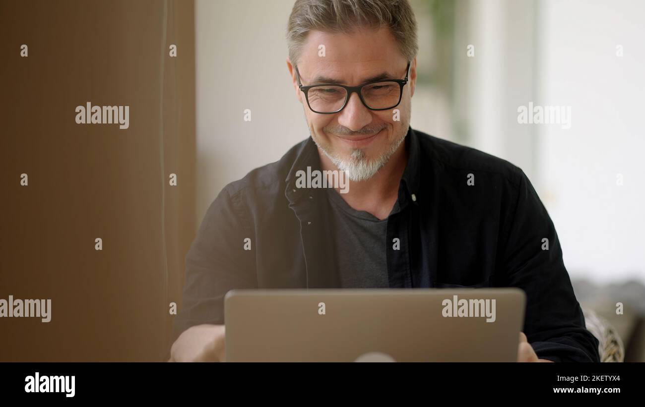 Businessman in home office. Middle aged man working with laptop ...