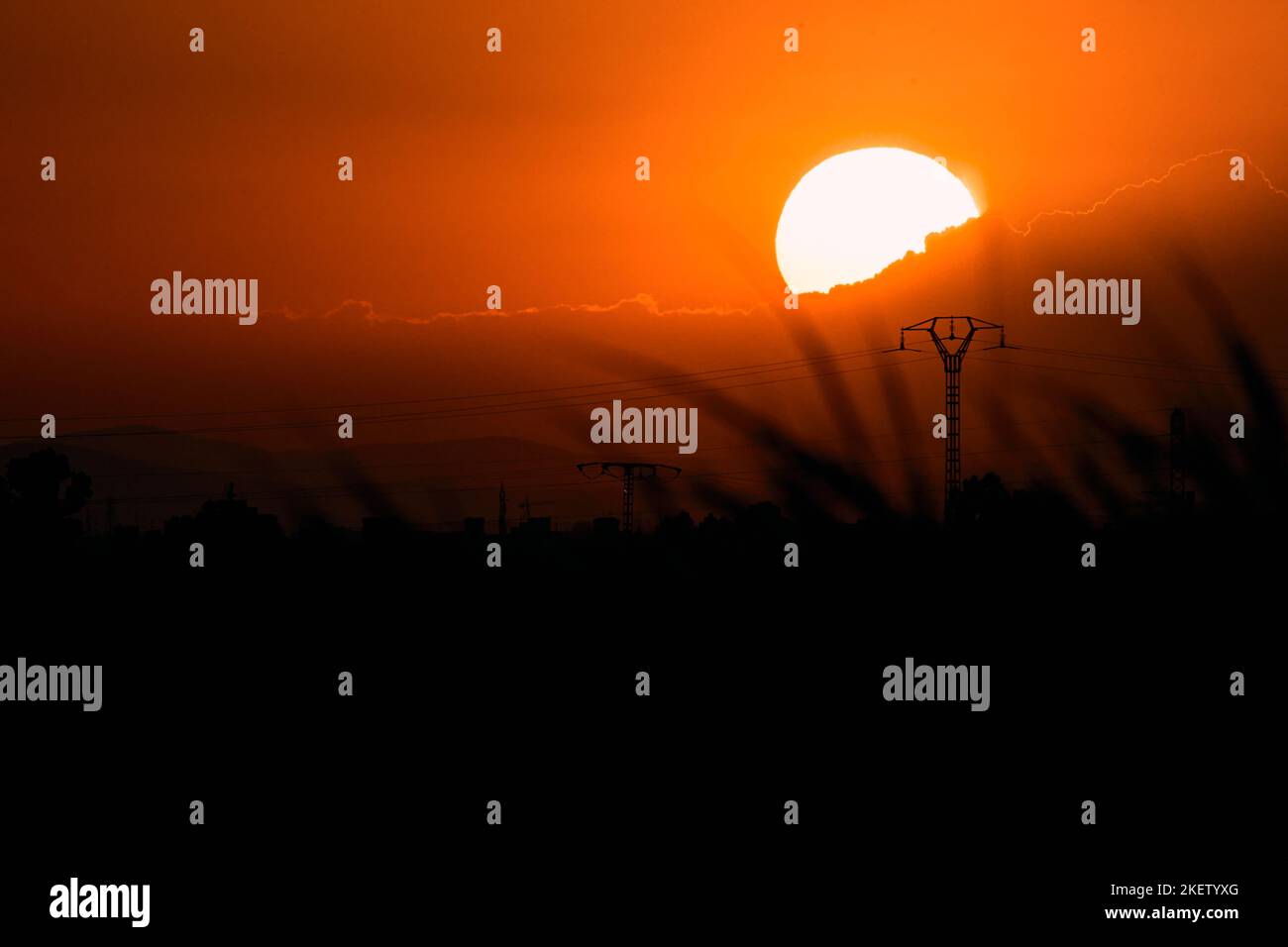 impressive sunset with the sun hiding behind the clouds over some ...