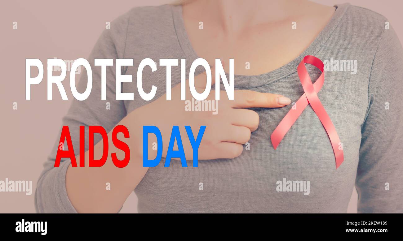 The hand is holding a red ribbon. AIDS awareness sign. World HIV Day symbol Stock Photo - Alamy