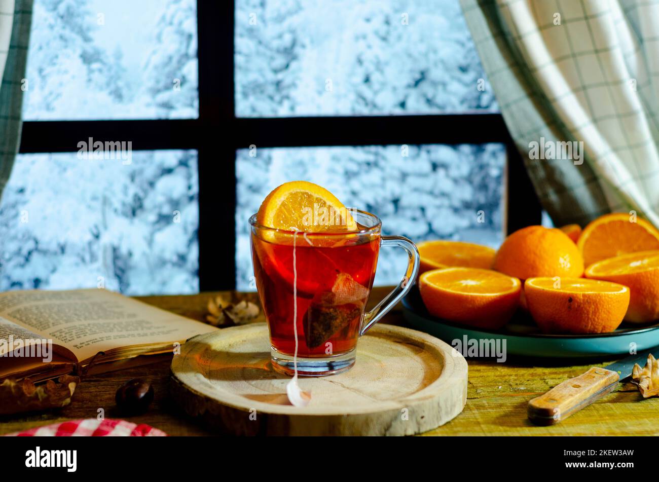 Cup of autumn tea with a book and yellow dry leaves near a window, copy ...