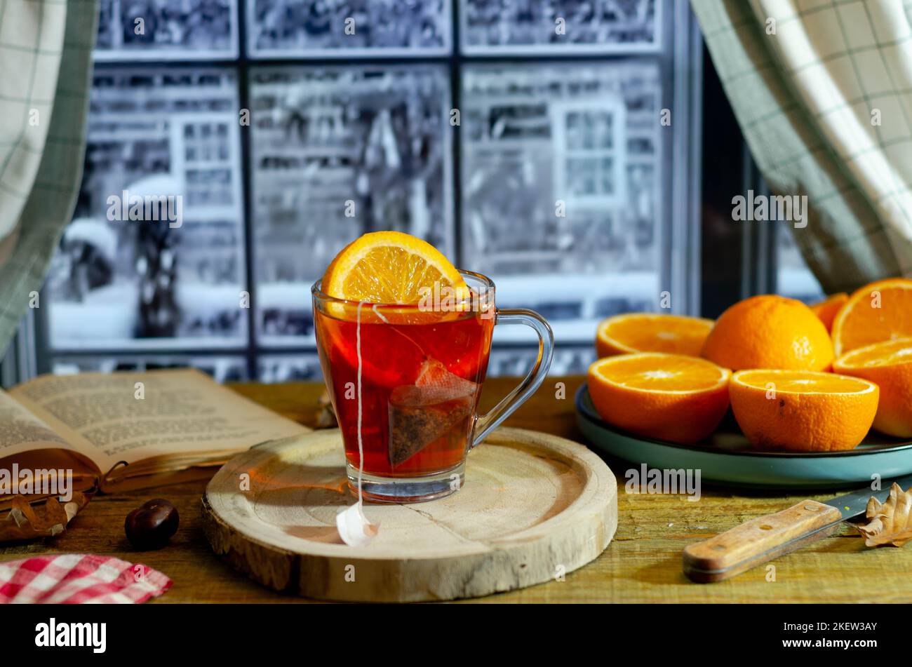 Cup of autumn tea with a book and yellow dry leaves near a window, copy ...