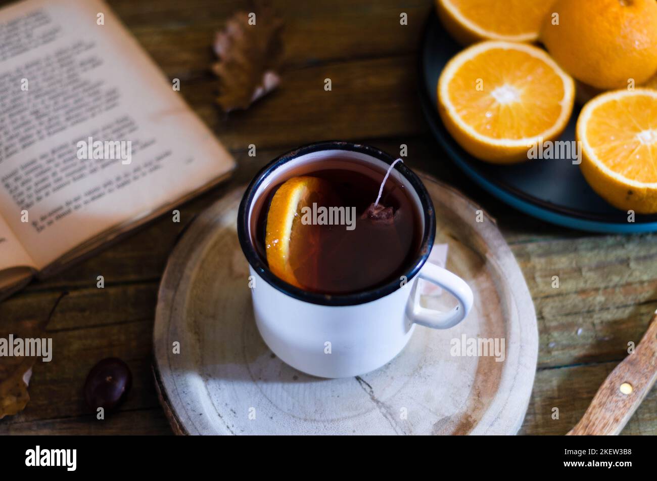 Cup of autumn tea with a book and yellow dry leaves near a window, copy ...