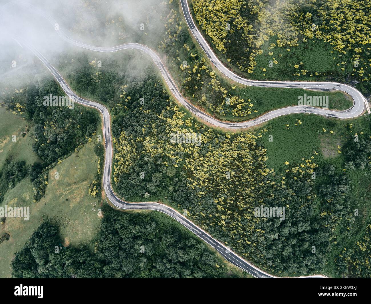 image taken with a drone of a long narrow and lonely road on the slope ...