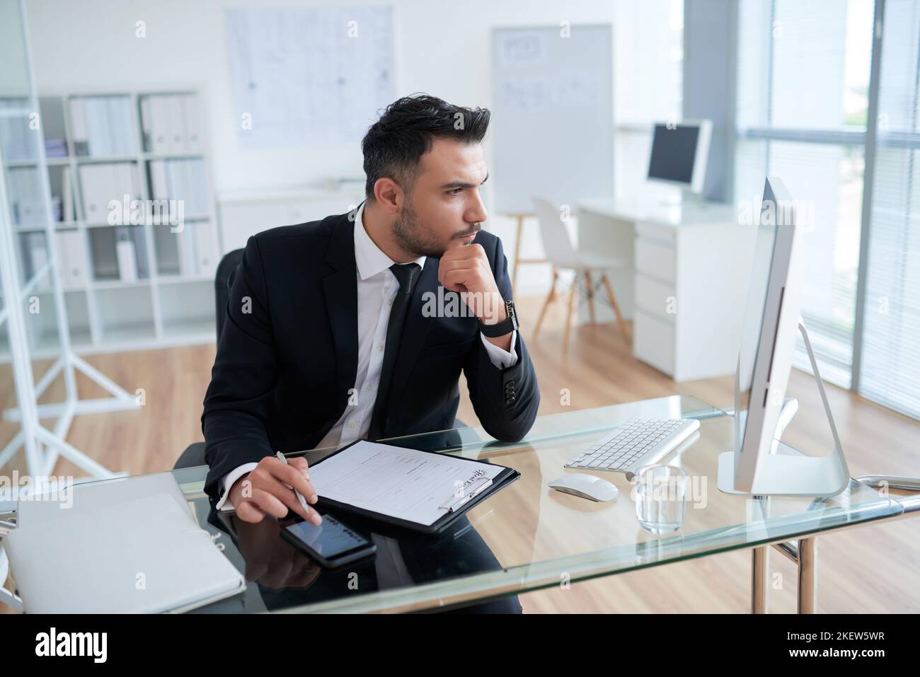 Turkish real estate broker reading data on computer screen Stock Photo ...