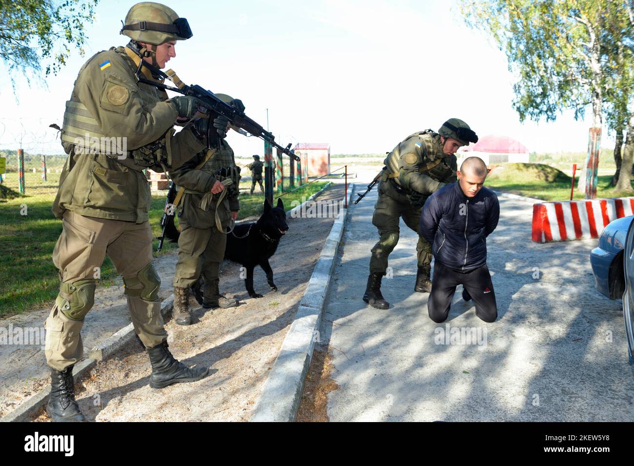 Soldiers arresting a suspect man, roadblock on a background. Checkpoint ...