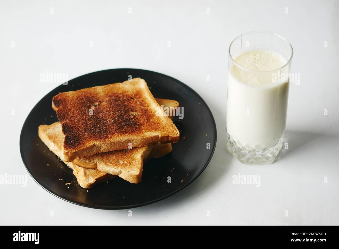 glass of milk and toasted bread on table Stock Photo - Alamy