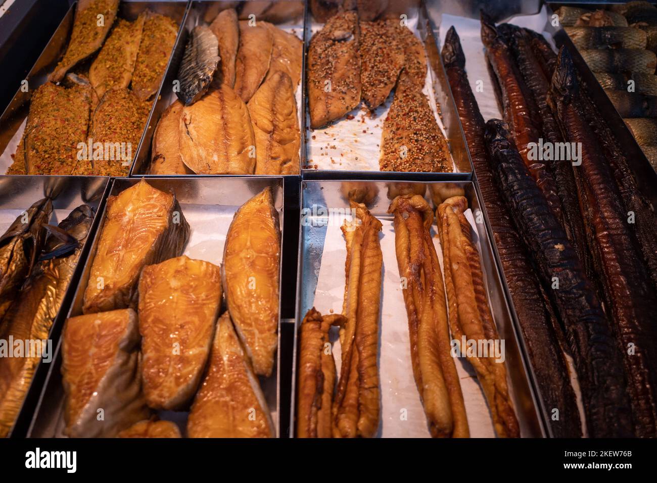 some different kinds of smoked fish lies in the display of a store ...