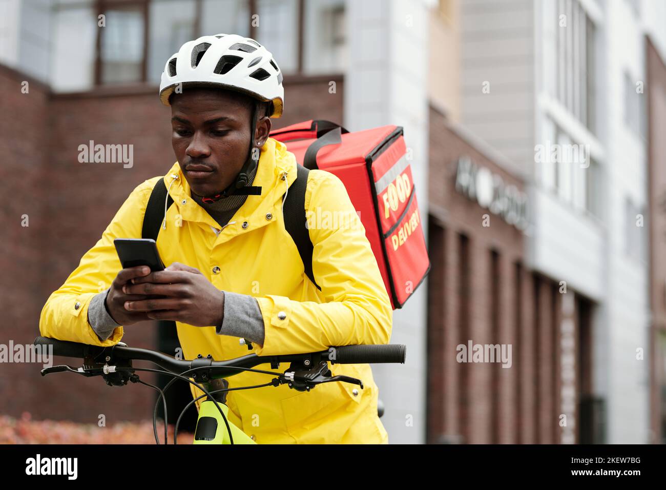 Serious black man in safety helmet and uniform of worker of food ...