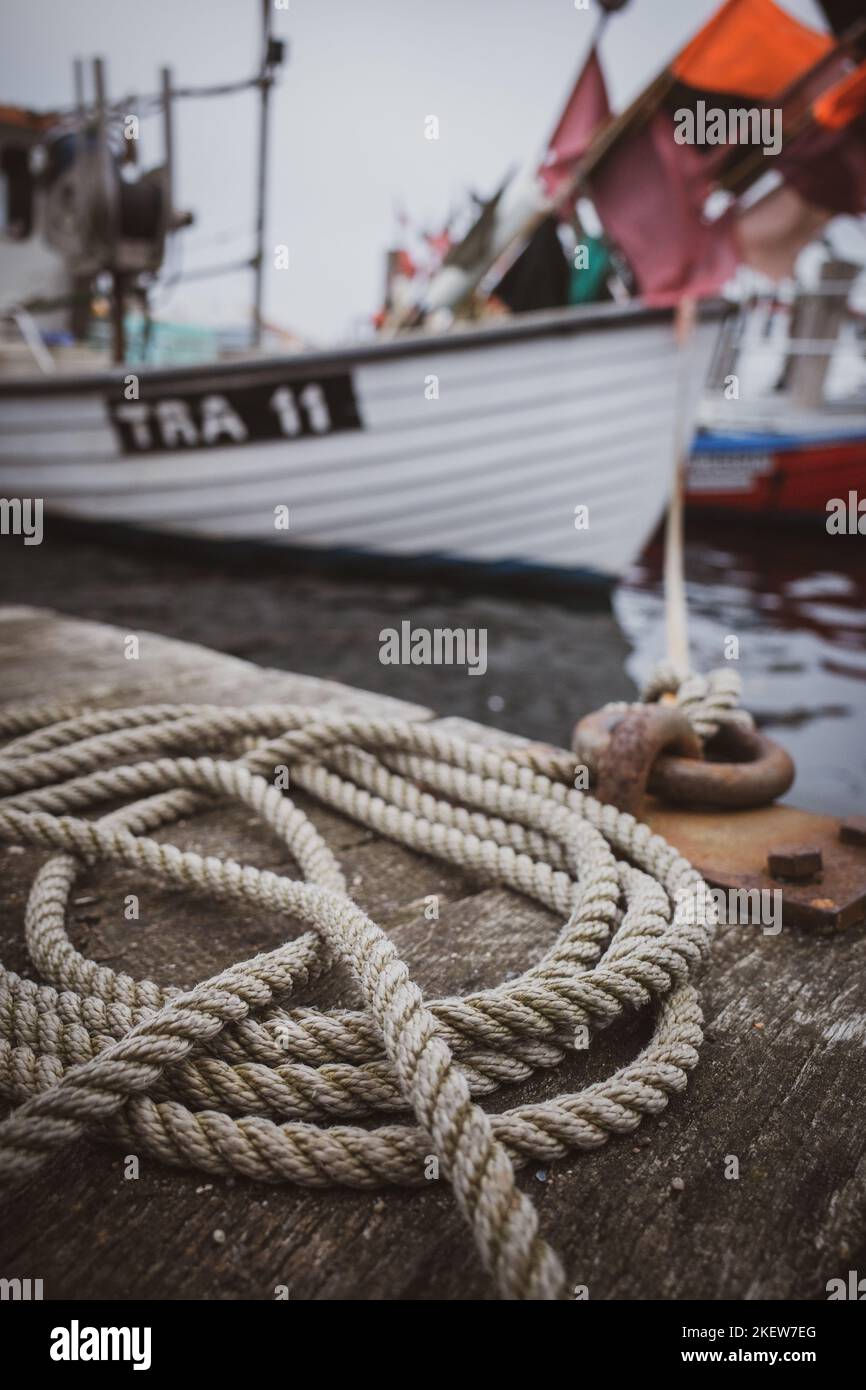 a ship is attached to a bollard in the harbor with a thick rope Stock ...