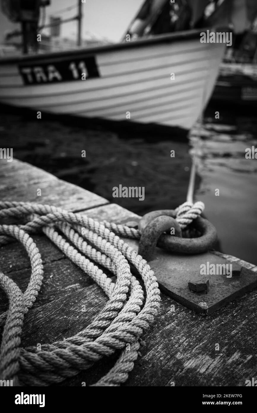 a ship is attached to a bollard in the harbor with a thick rope Stock ...