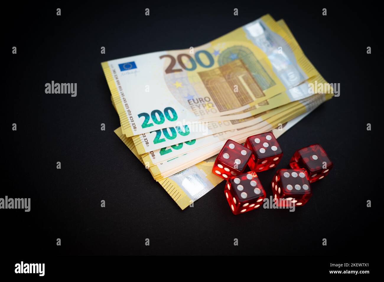 red dice lay on a stack two hundred euro banknotes Stock Photo - Alamy