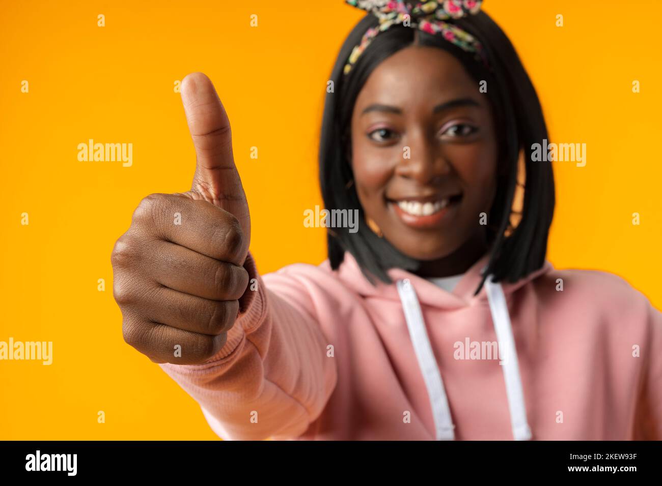 African young woman over isolated yellow background with thumbs up ...