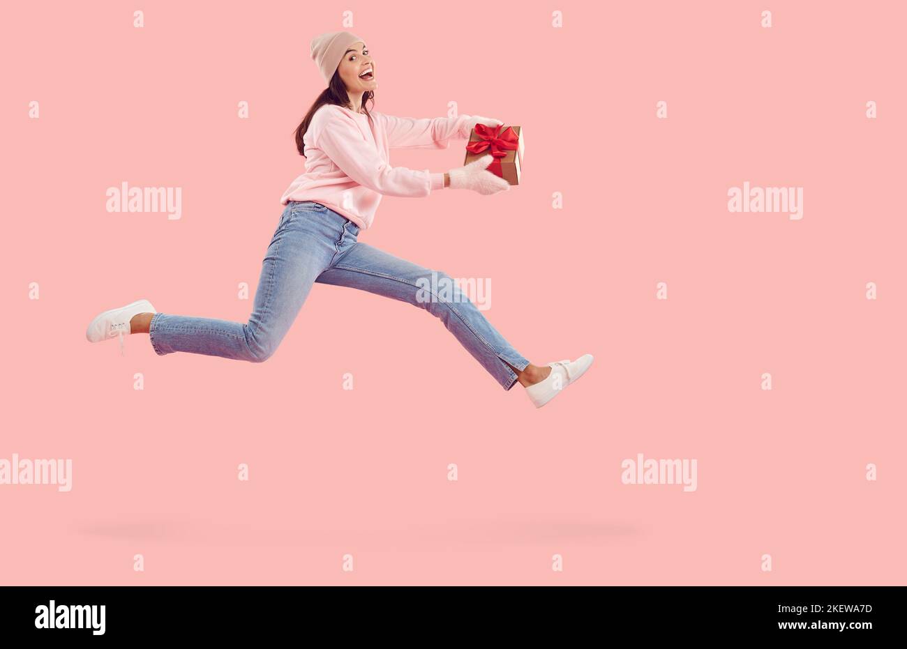 Happy excited woman holding new year present, jumping up and flying on ...