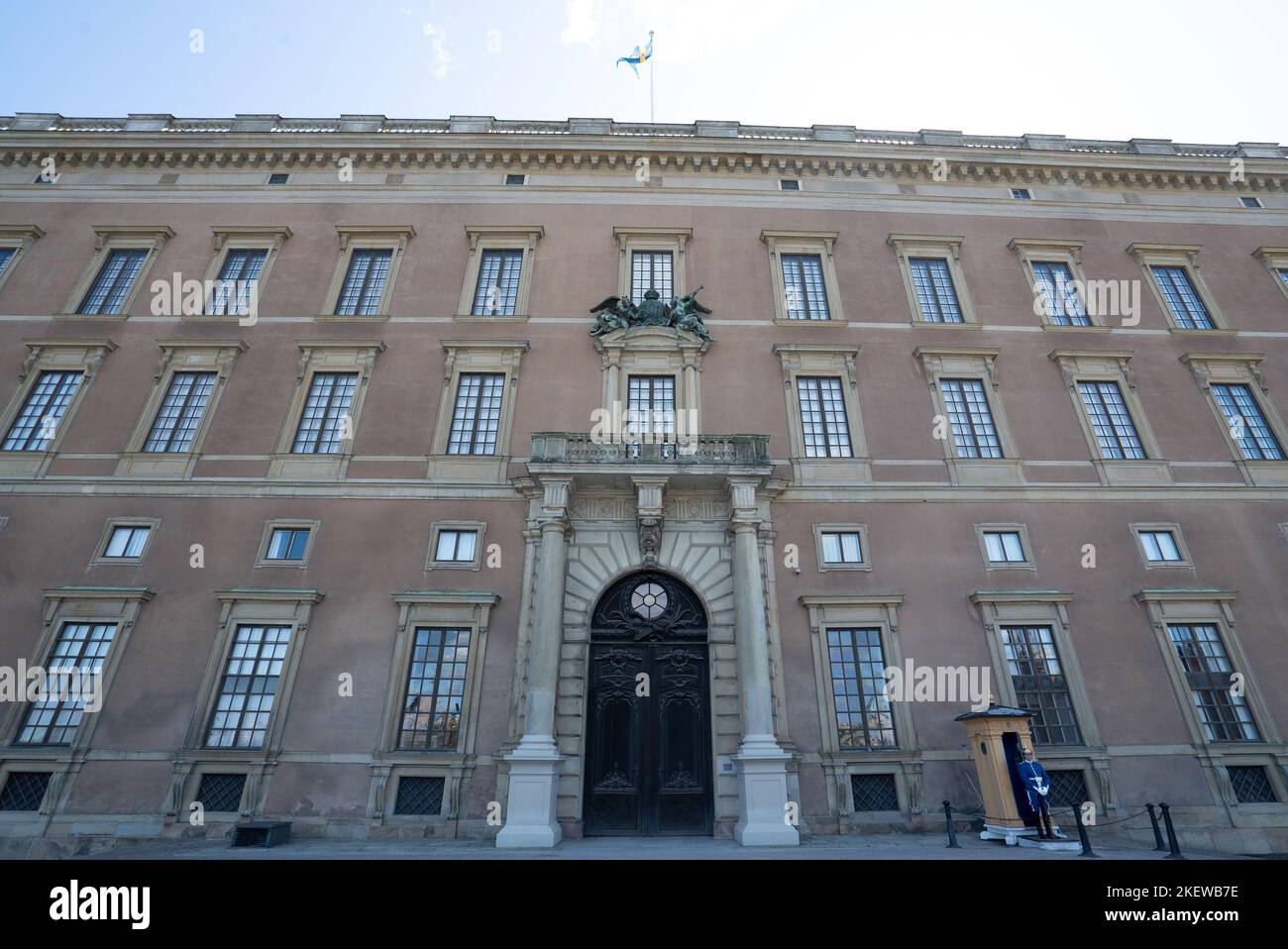Sweden Flag flying above The Royal Palace, on a sunny day, with a guard ...