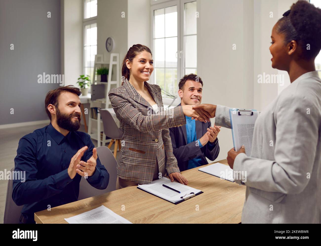 Happy HR manager shaking hands with a candidate after a successful job ...