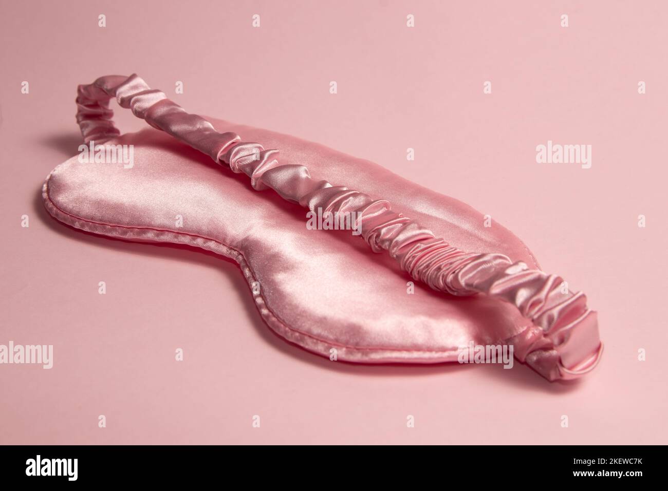 Pink silk sleeping mask on a pastel pink background Stock Photo - Alamy