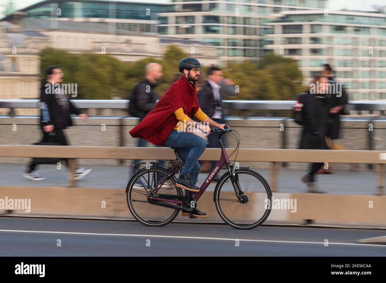 A man cycling during rush hour, across London Bridge, London, UK. 18 ...